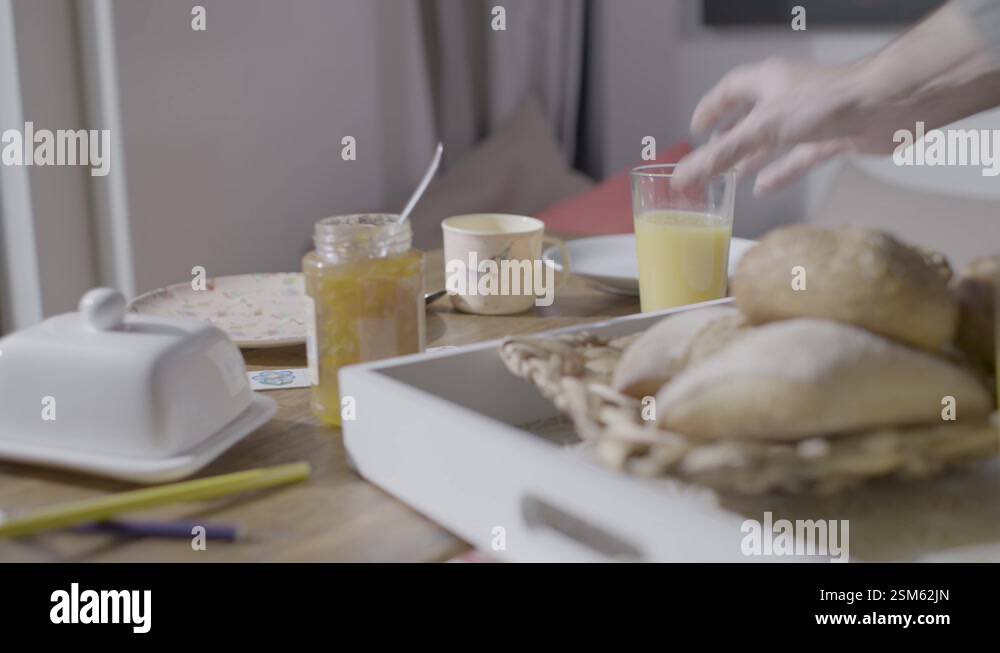Man's hands serving nutritious breakfast with bread, jam and orange ...