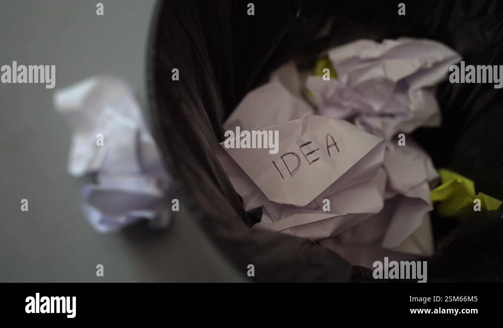 unworthy planning idea on crumpled paper thrown in trash bin, close up ...
