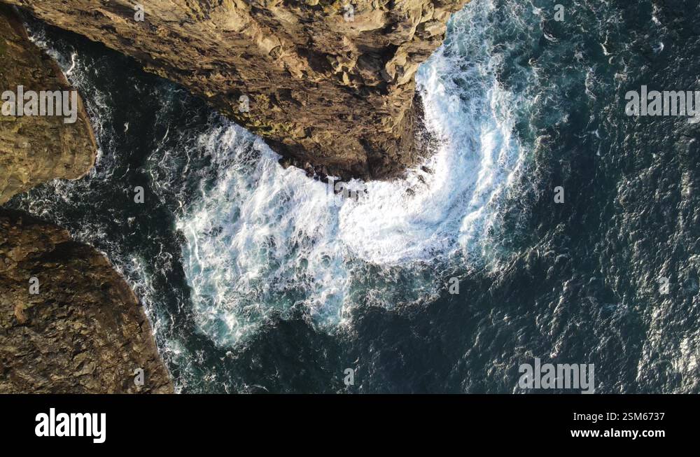 Static top-down drone footage of a very steep cliff on the Vagar island ...