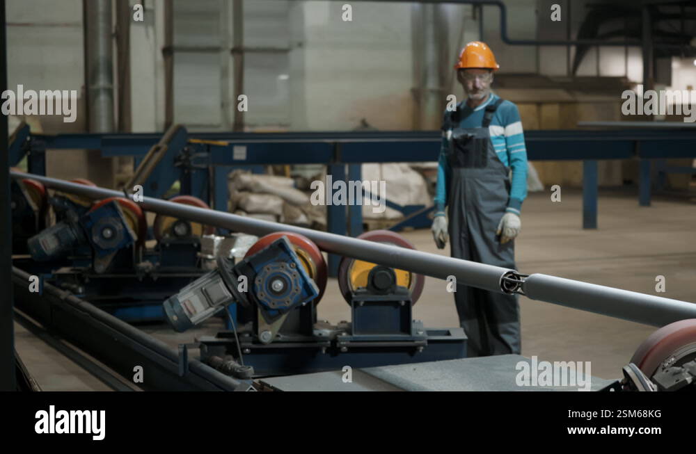 Worker supervising the tube manufacturing process on the factory ...