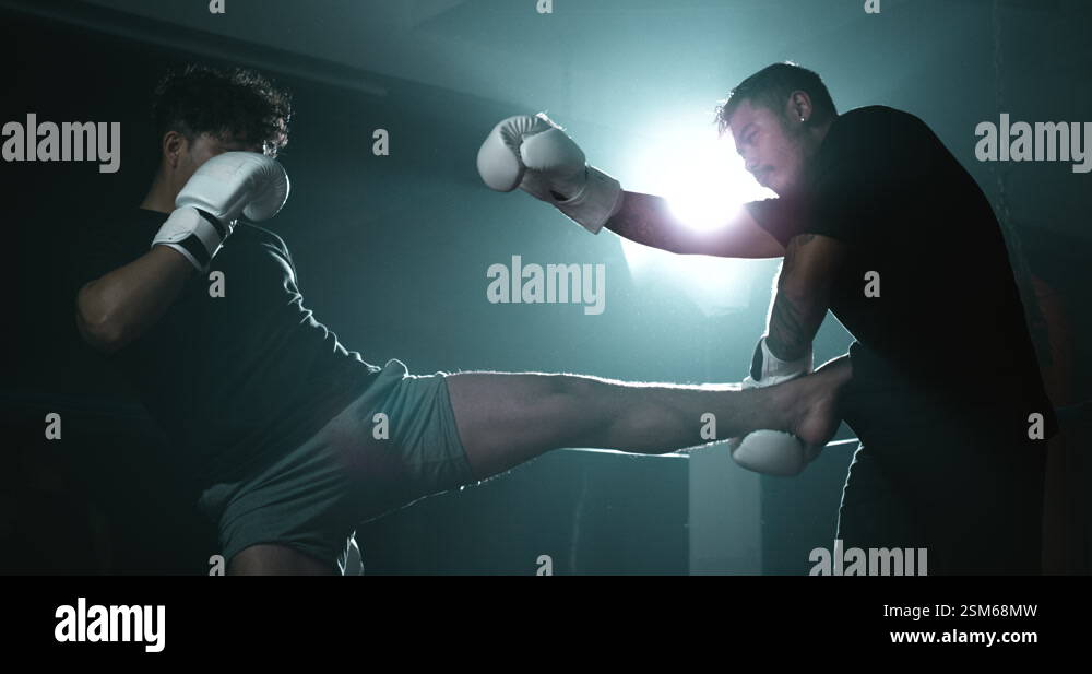 Two Men inside ring engaged in fight using Muay Thai fighting technique ...