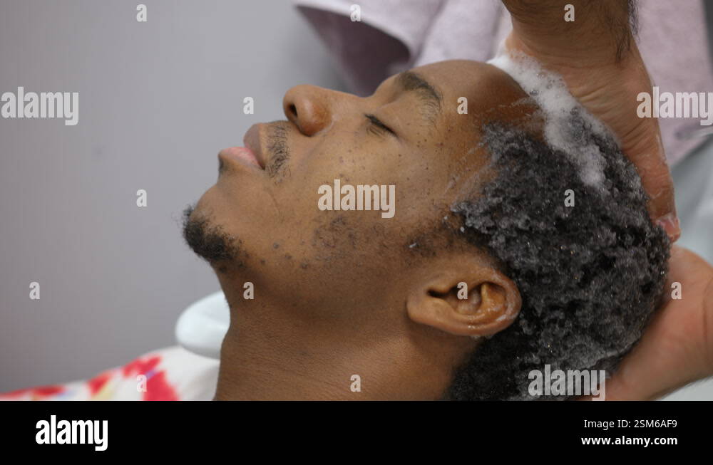 Professional stylist hands foam shampoo and rub detergent on male ...