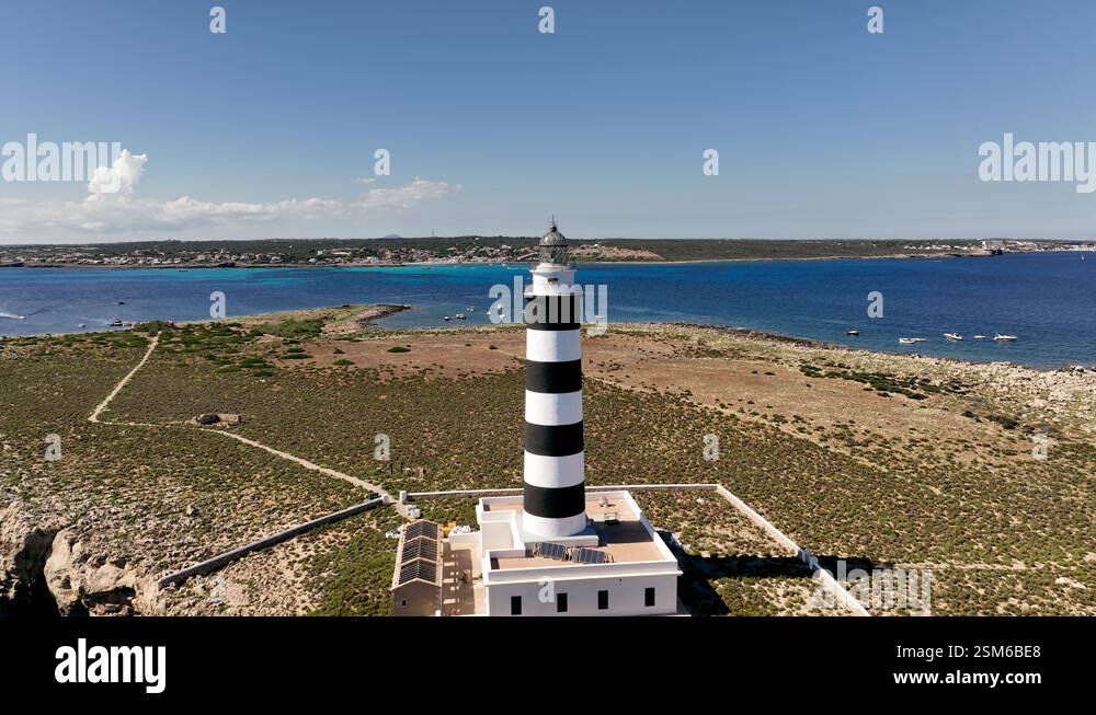 striking lighthouse stands sentinel on Minorca's rugged cliffs Stock ...