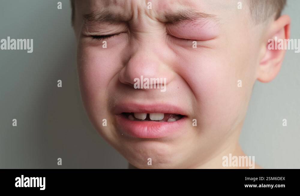 Dramatic portrait of a crying 7 year oldboy. Tears flow from the eyes ...