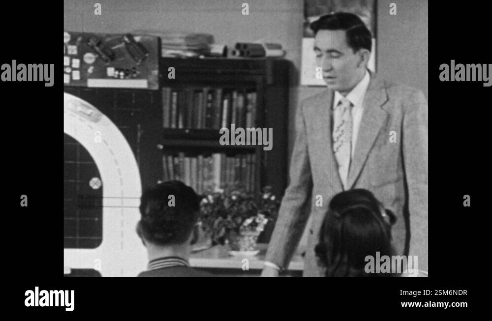 1950s: High school. Teacher speaks and gestures at driving diagram ...