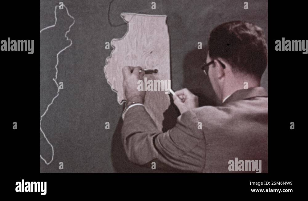 1950s: Man holds stencil of map by handle as he draws outline of map on ...