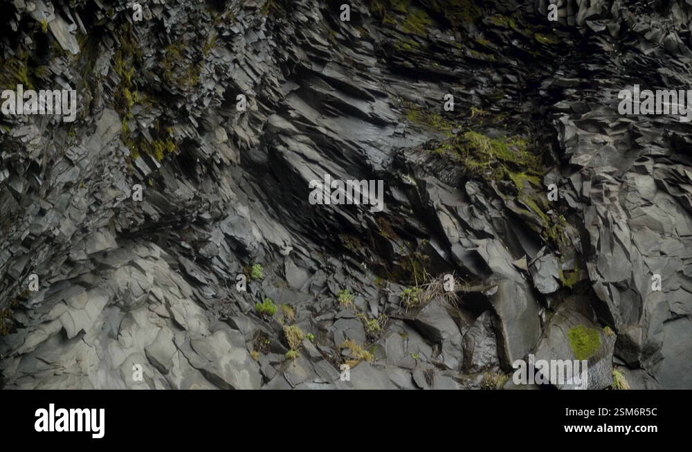 Rocky wall with unique hexagonal pattern in a wet cave in Iceland Stock ...