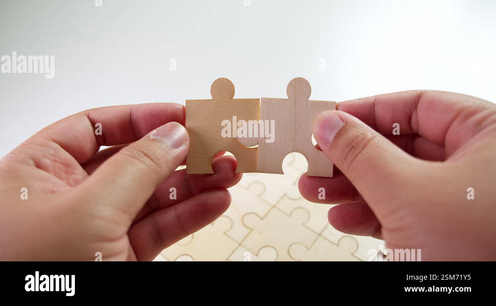 Jigsaw Puzzle pieces on the table then the lefthand and the righthand ...