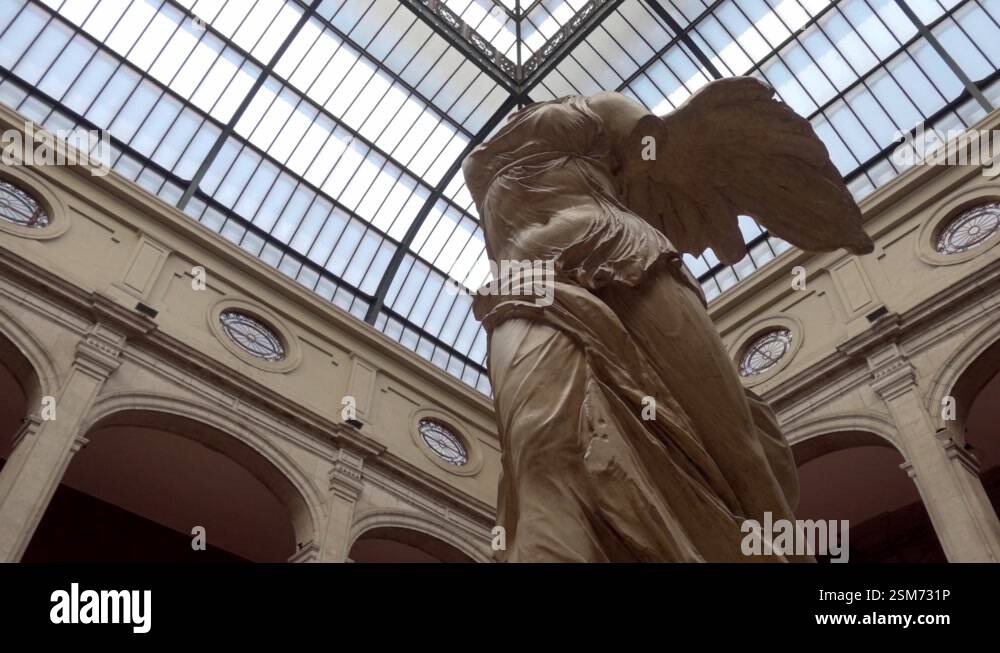Slow orbiting shot around the base of an angelic statue in a museum in ...