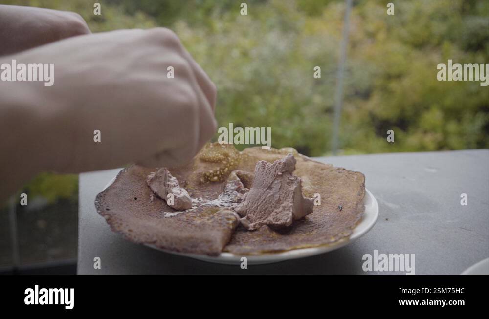 A man eating pancake with icecream at the terrace near by nature ...