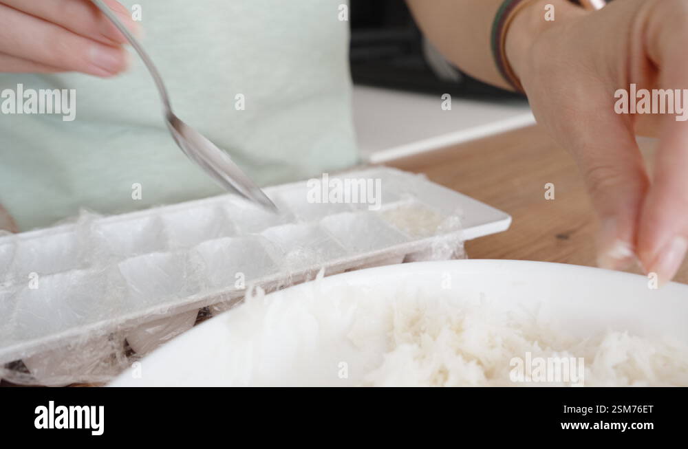 The Woman Places the Coconut Shreds into a Plastic Ice Tray, she is ...