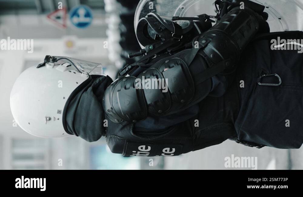 Cinematic vertical shot of unrecognizable police officer in full gear ...