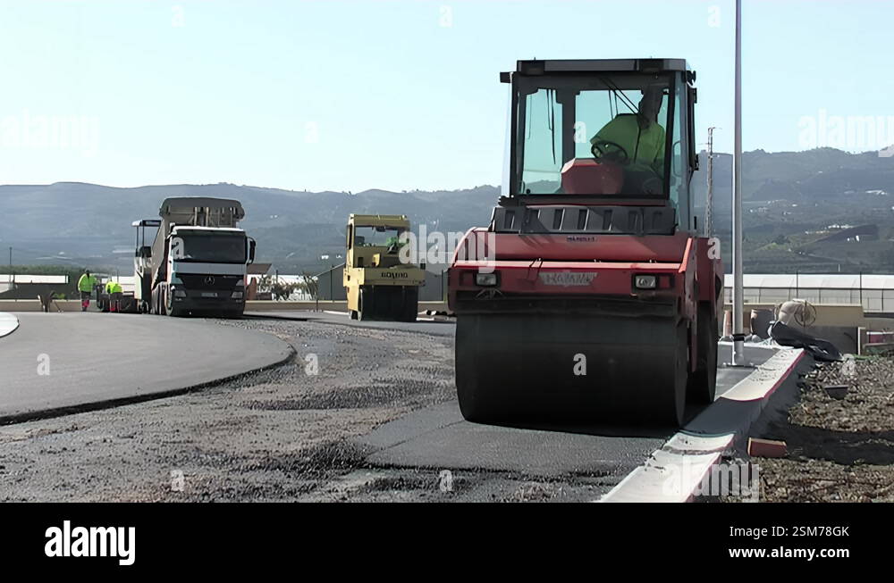 Steamroller and asphalt roller apisionating new tar in a road Stock ...