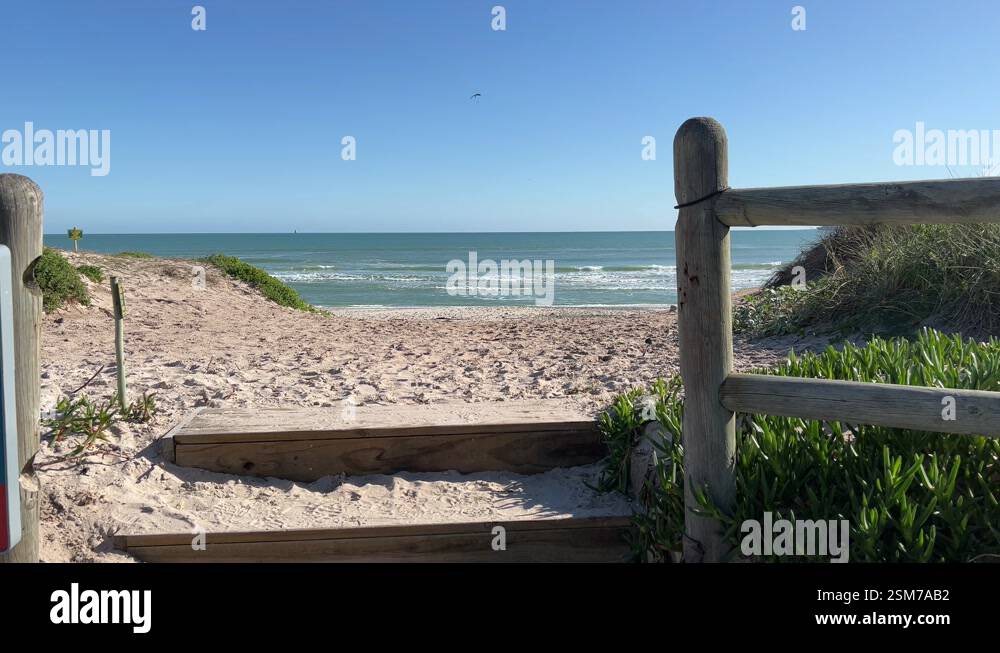 Beach wooden steps with a sandy path between the small beach sand dunes ...