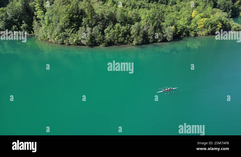group team of people coordinating riding thin tiny kayak with paddles ...
