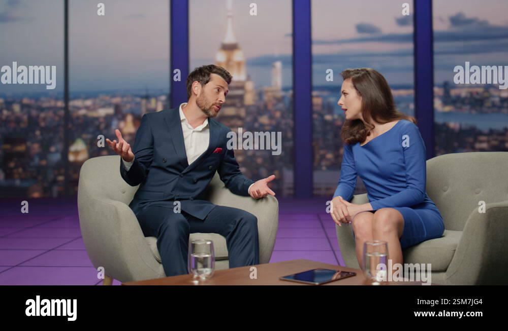 Two presenter talking tv show sitting armchairs studio. Bearded man ...