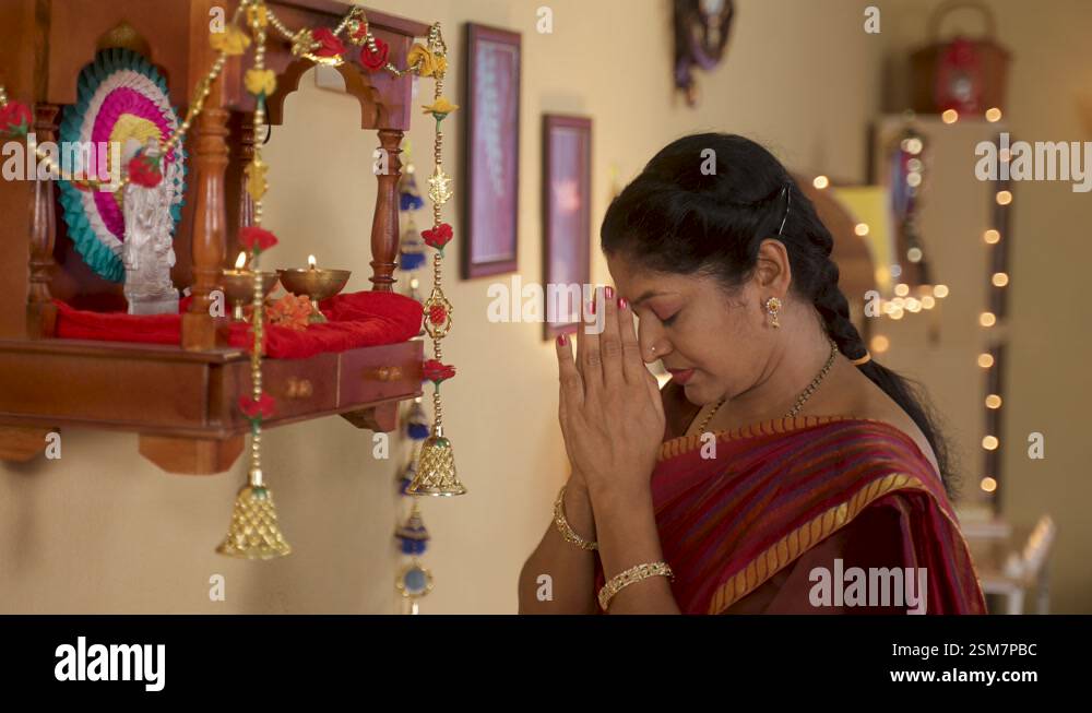 devotional Indian woman praying to god by folding hands in front of ...