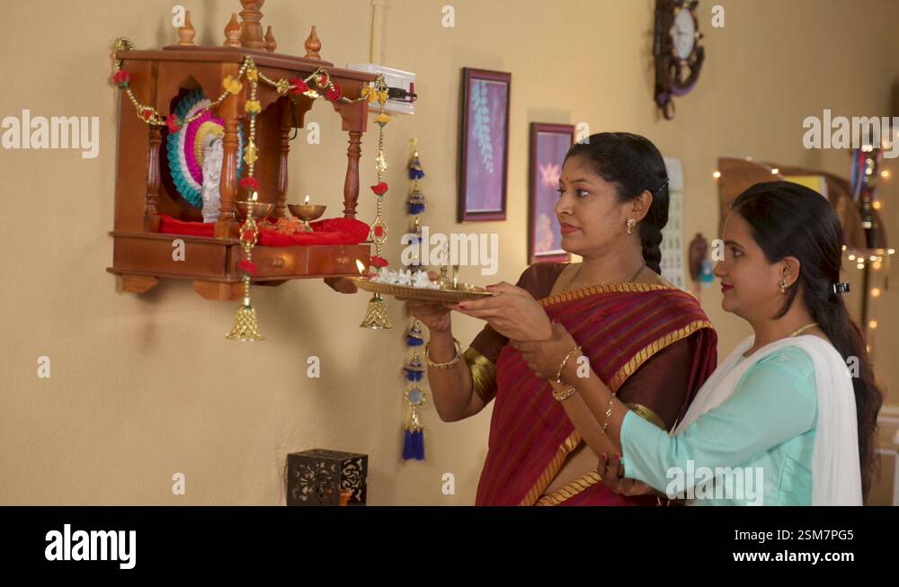 devotional Mother and daughter offering doing puja by offering aarthi ...