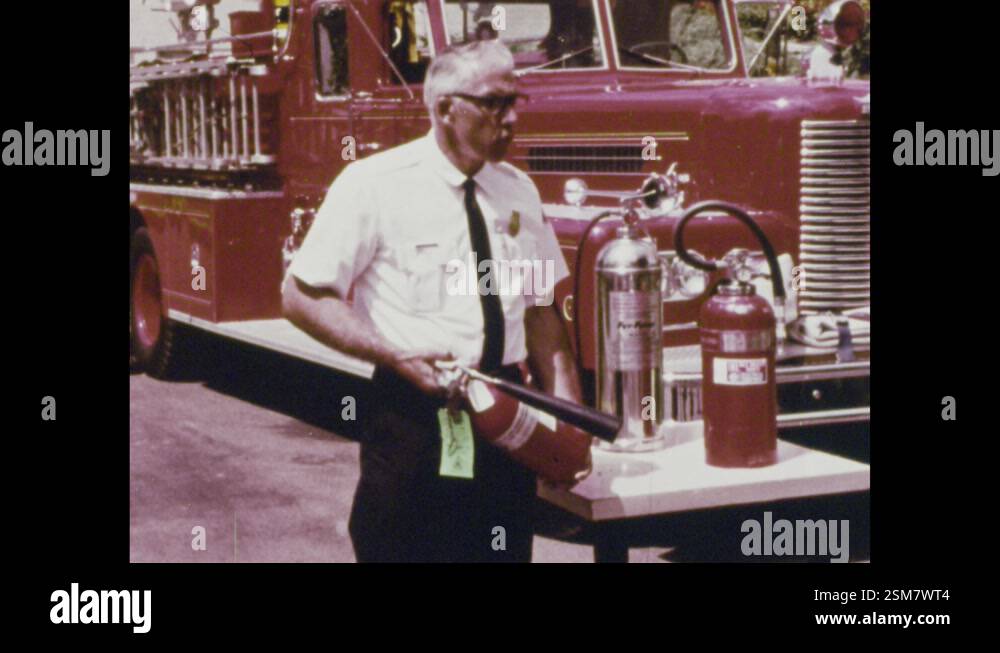 1960s: Fire chief demonstrating the operation of a fire extinguisher ...