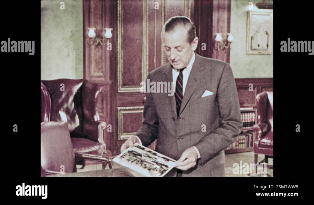 1960s: Alistair Cooke walking across the study, places a photo on a ...