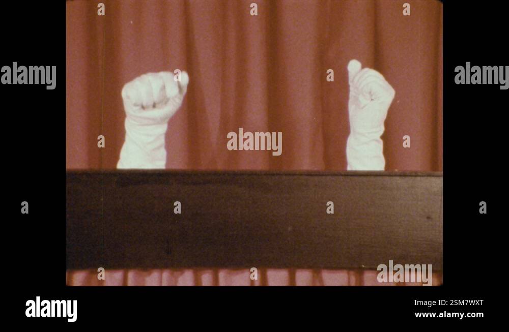 1970s: Two puppets leave stage. Two gloved hands rise and move around ...