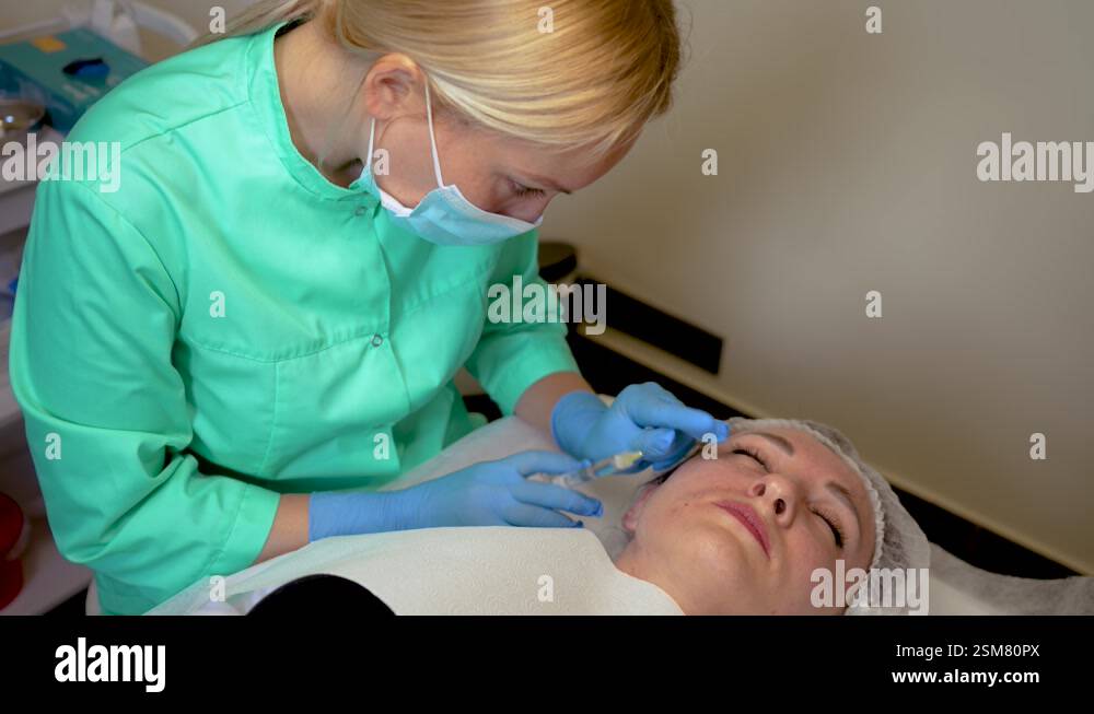Cosmetologist doing neurotoxin injections for middle aged woman client ...