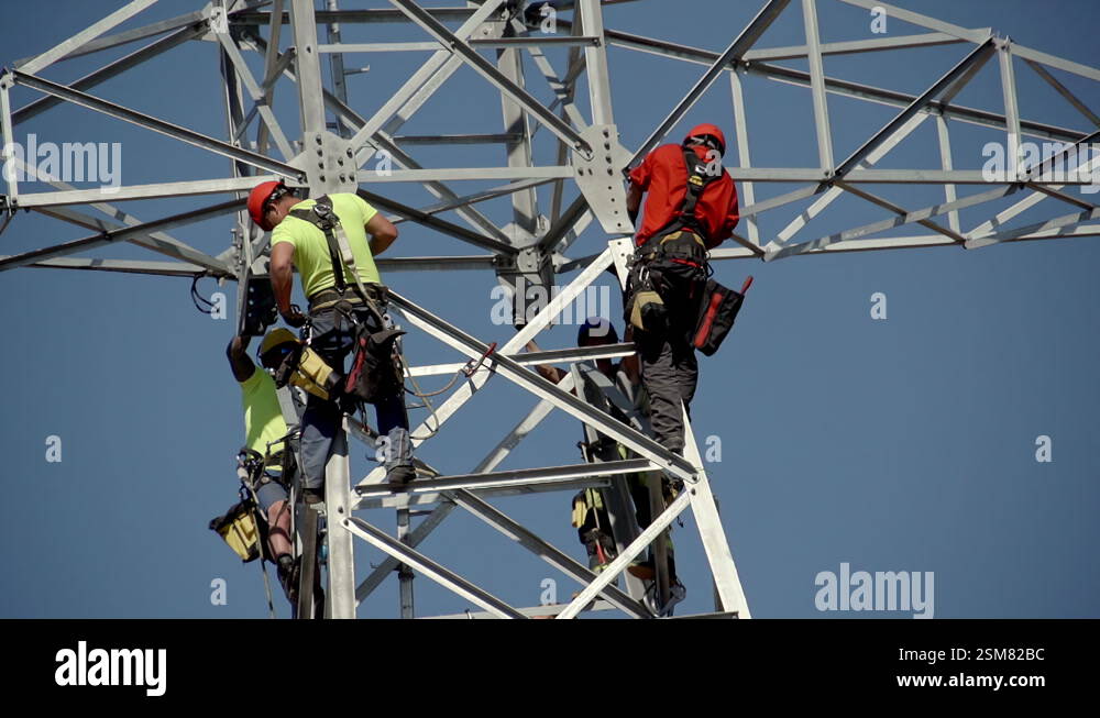 Close up of workers at height in a high-voltage pole. Drone shot Stock ...