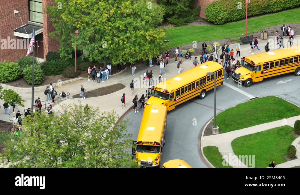 Students boarding buses during American school dismissal. Aerial Stock ...