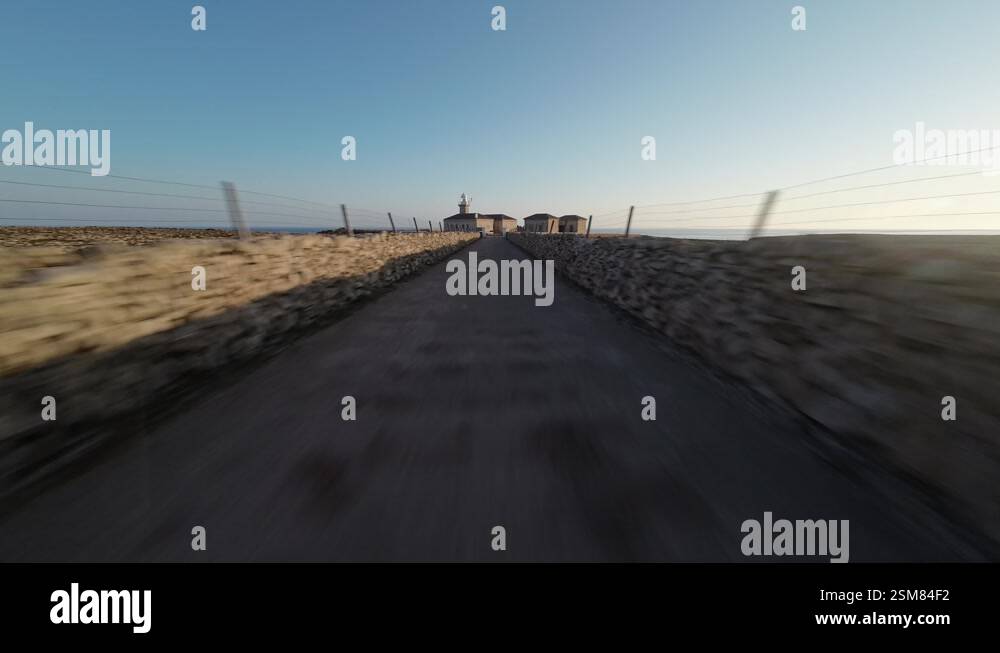 Racing view of narrow road leading up to the Fano de Punta Nati ...