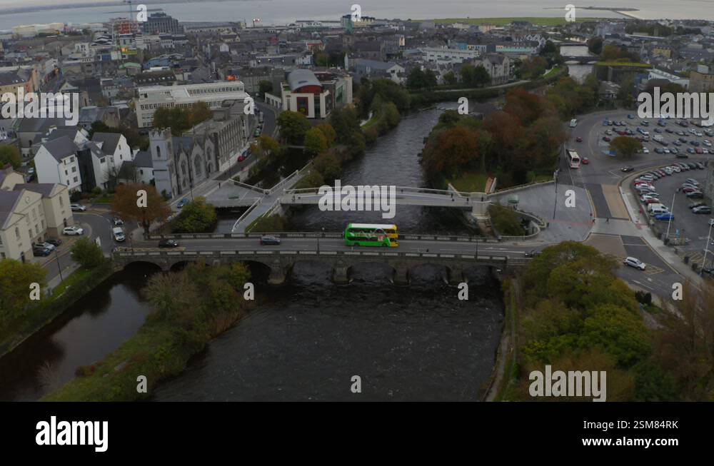 The pedestrian bridge in Galway, the River Corrib, the cathedral. Shot ...