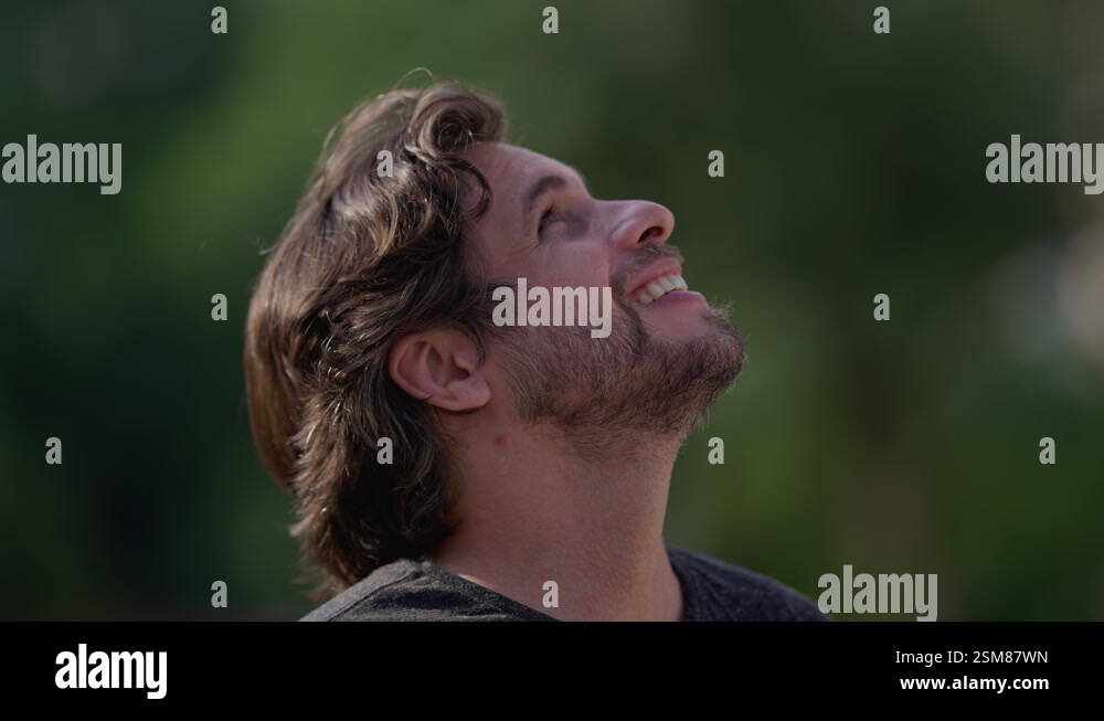 One happy young man looking up at sky with HOPE and FAITH. Smiling male ...