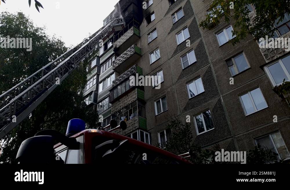 A fireman standing on a fire escape extinguishes the balcony of the ...