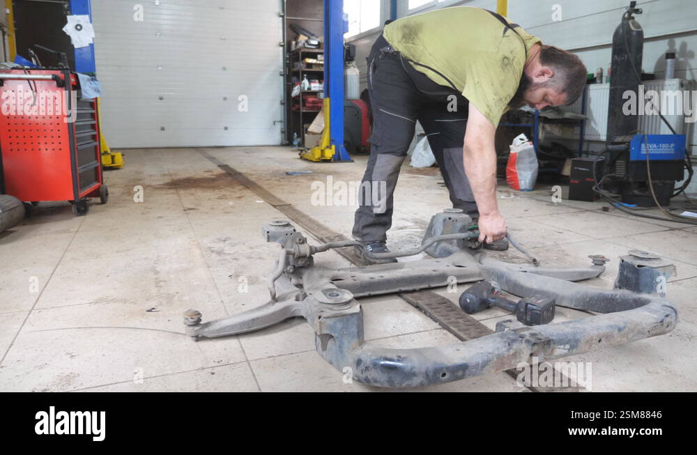 Auto mechanic assembles the subframe of car before installation at ...