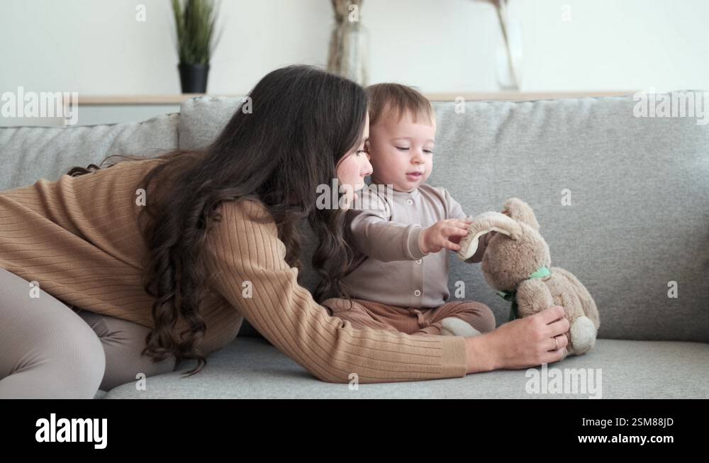 Loving Mother Playing with Young Son Using Soft Toy in the Living Room ...