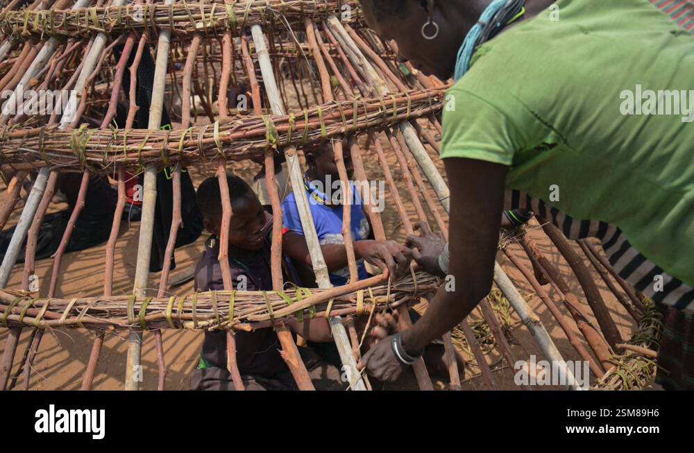 African women building wooden hut in rural village of Matheriko tribe ...