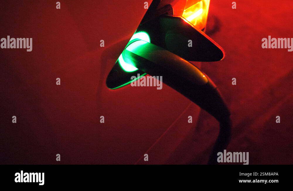 Electric car charging at night time. Power connector inserted into EV ...