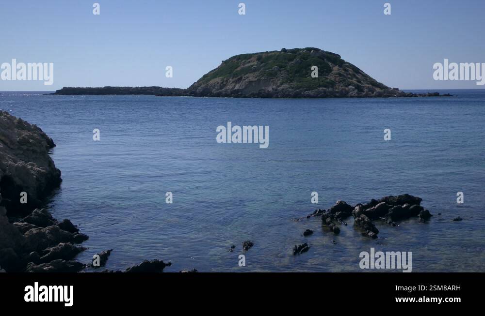 Mediterranean seascape, a small island close to the coast, reverse slow ...