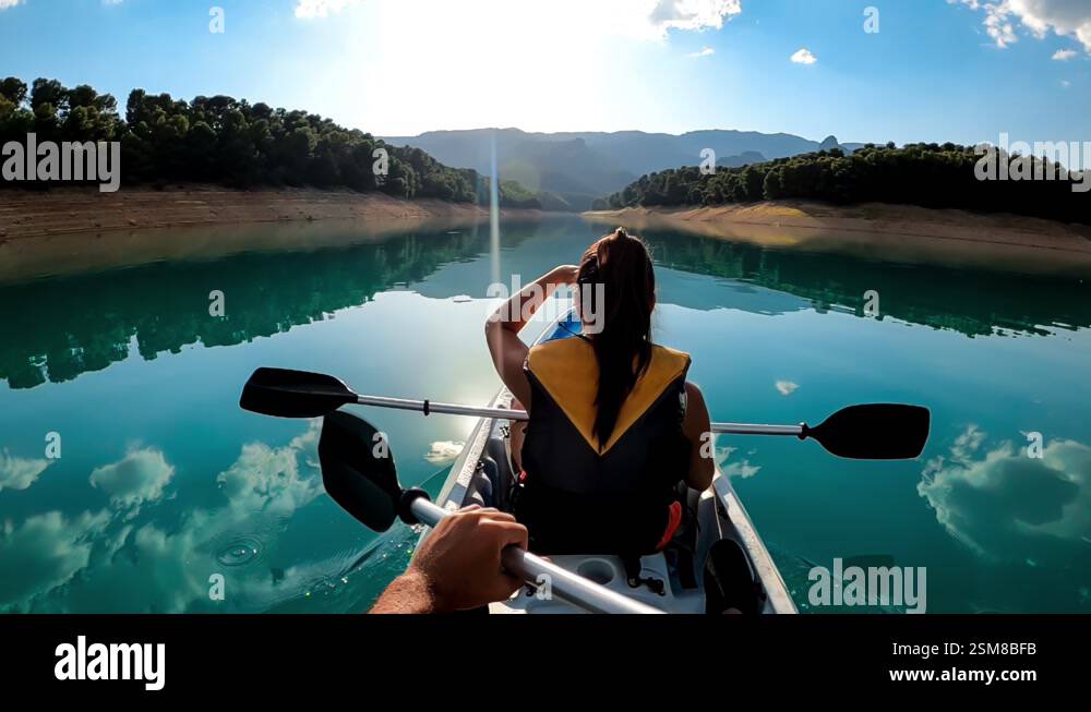 Kayakers couple kayaking rowing on kayak at lake on a scenic nature ...
