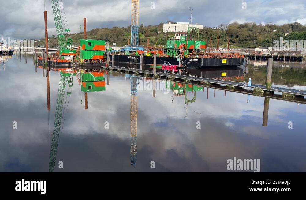 Construction barge on The River Suir building a footbridge on a calm ...