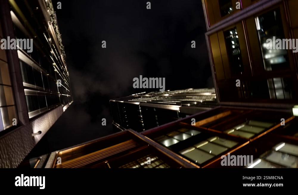 tilt up view on dark and high building in downtown in night, cinematic ...