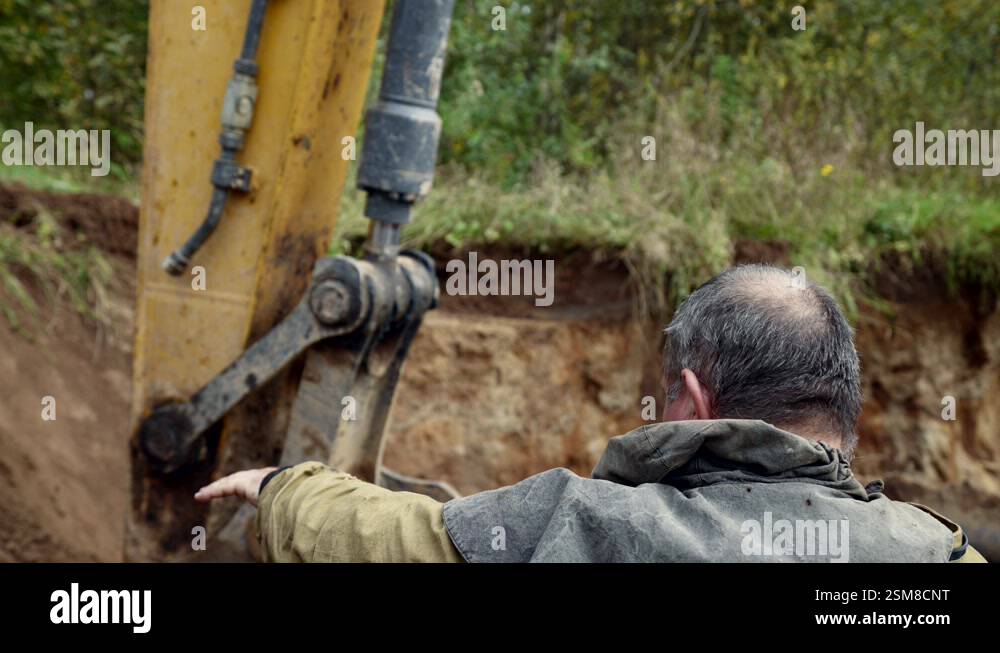 builder man correcting work of excavator bucket, professional foreman ...
