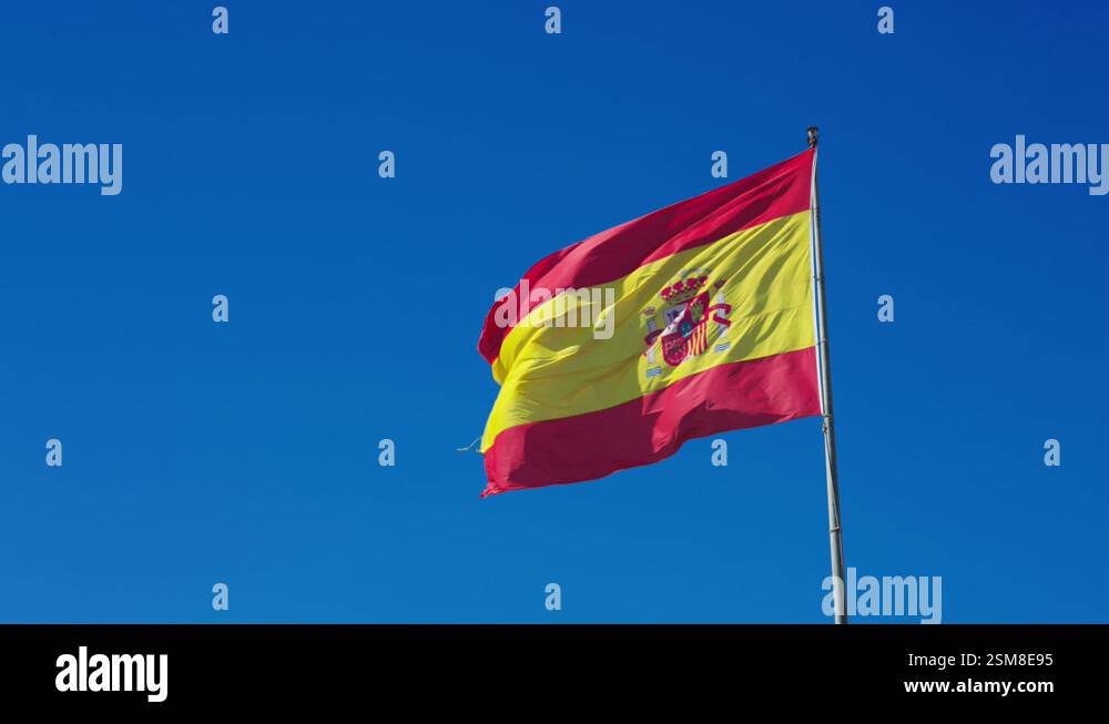 Spanish flag waving, slowmotion, in front of blue sky Stock Video ...