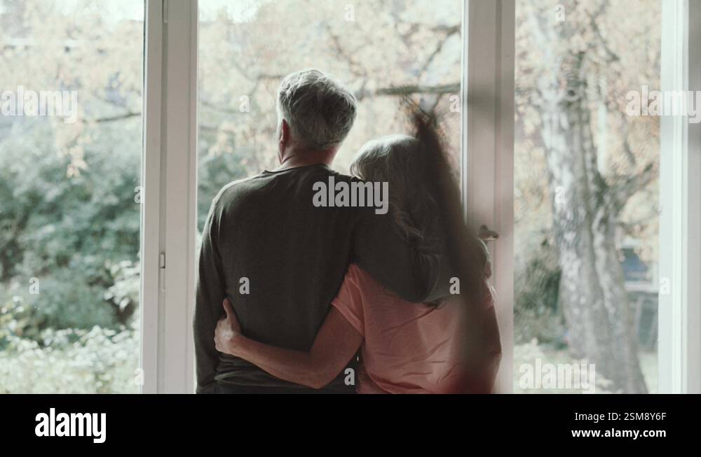 Contented elderly couple gaze out the window and at each other Stock ...