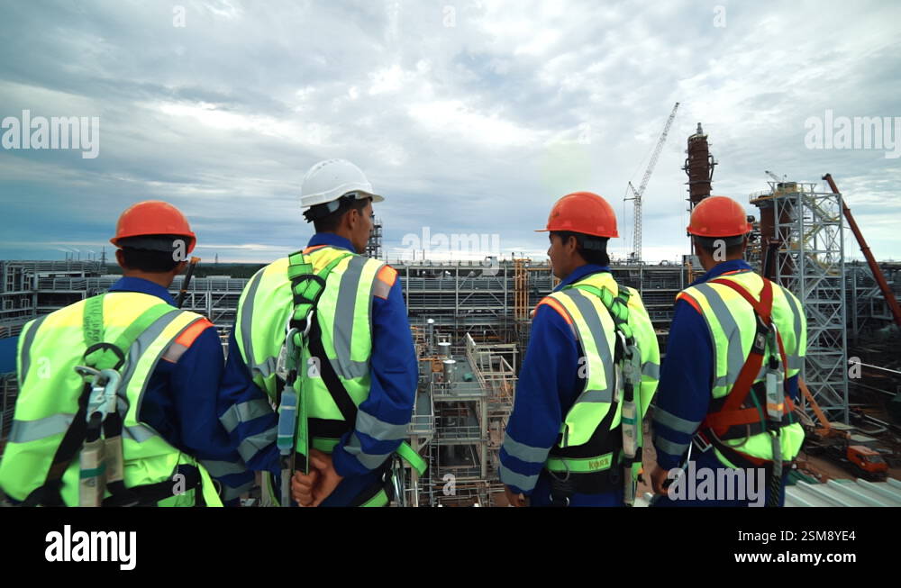 Group of industrial metalworker colleagues protective uniform examining ...