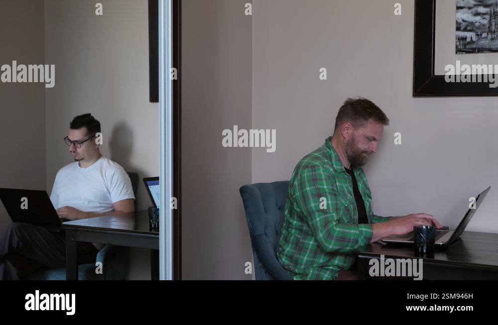 Married couple working remotely. Young partners busy using laptops at ...