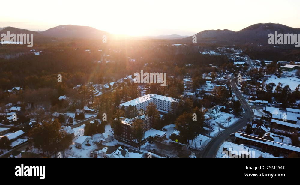 Aerial Forward Tilt Down Shot Of Houses With Snow Near Mountain Ranges ...