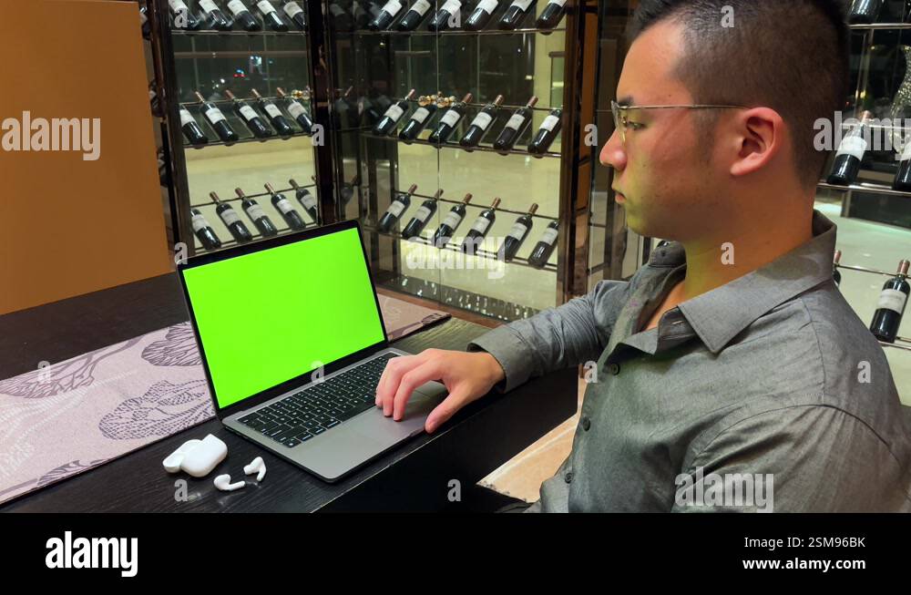 Asian Millennial Man Scrolling on Trackpad of Laptop with Green Screen ...