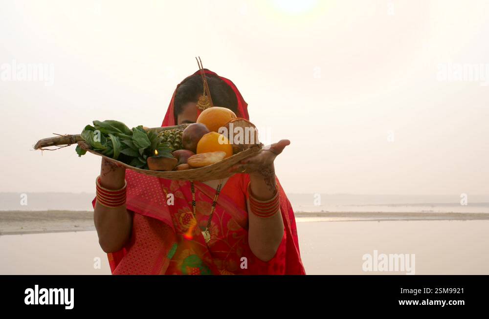 An Indian devotee in traditional attire offers prayers to the sun ...