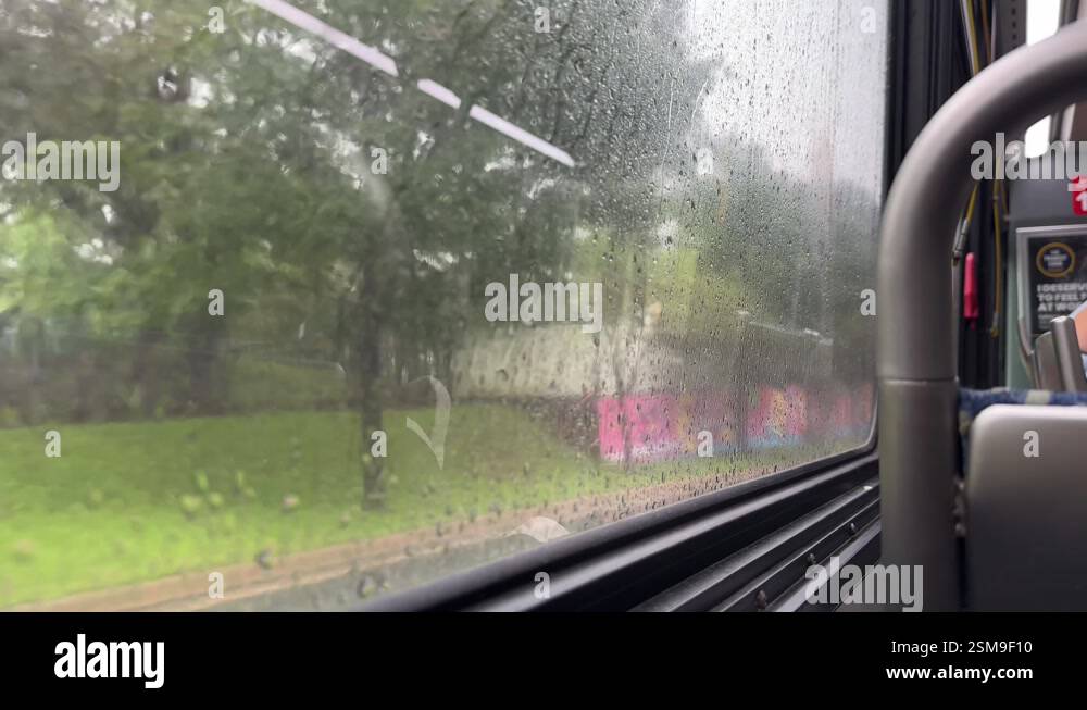 Window with raindrops on a bus driving through the city streets on a rainy day Stock Video ...