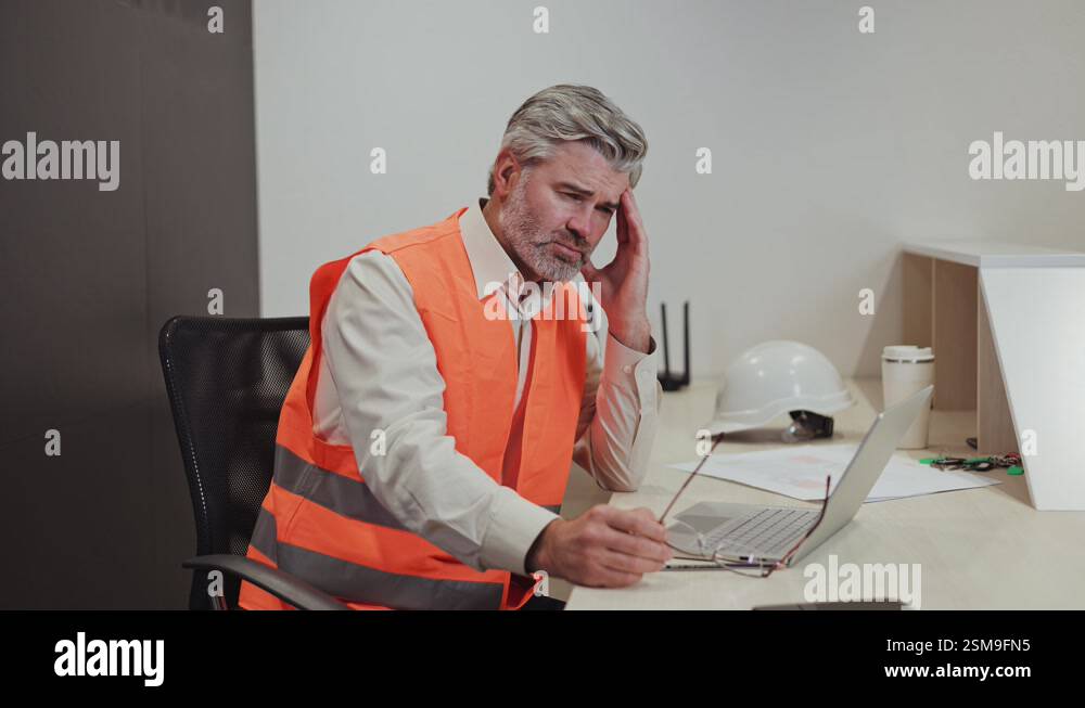 Male taking off goggles because feeling headache while typing on ...